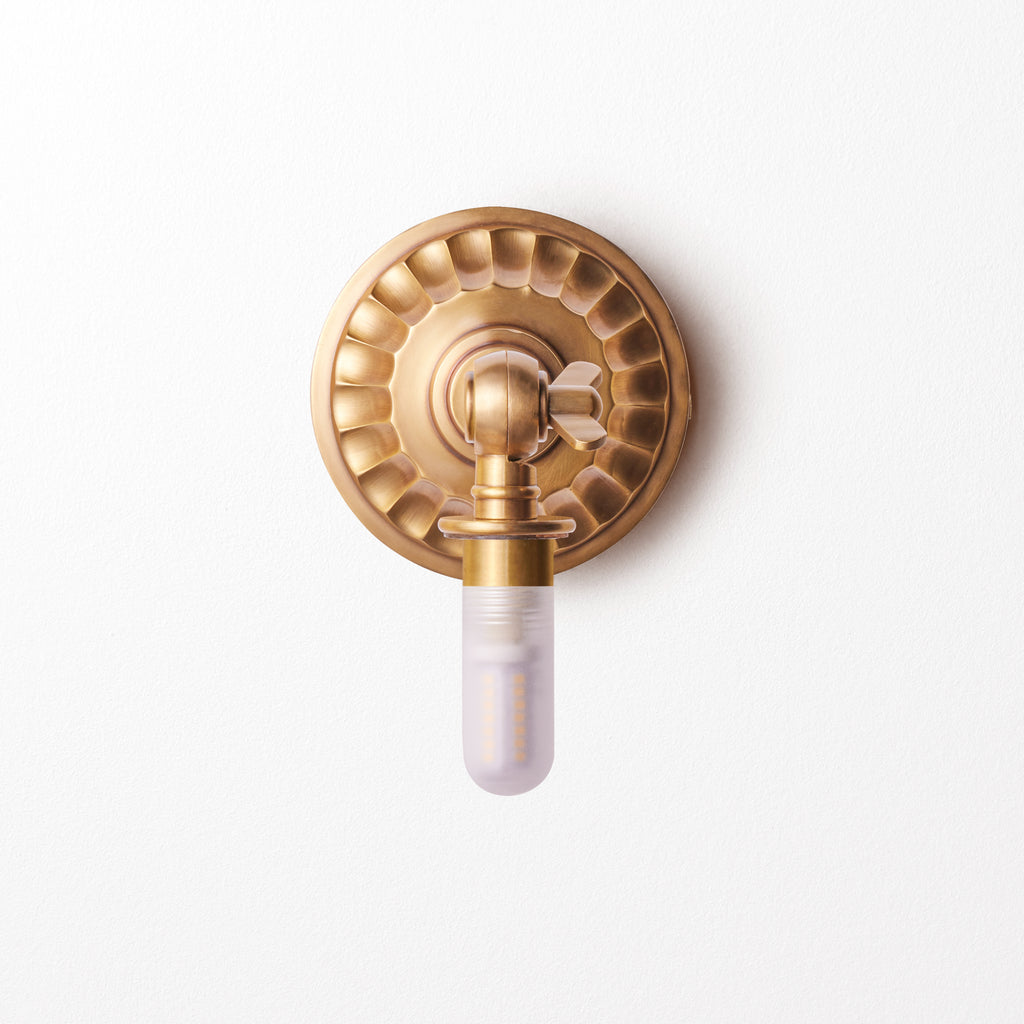 Bathroom Rose wall fixture in antiqued brass