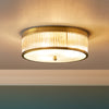 Round Roddy flush mount ceiling light in antiqued brass and clear glas