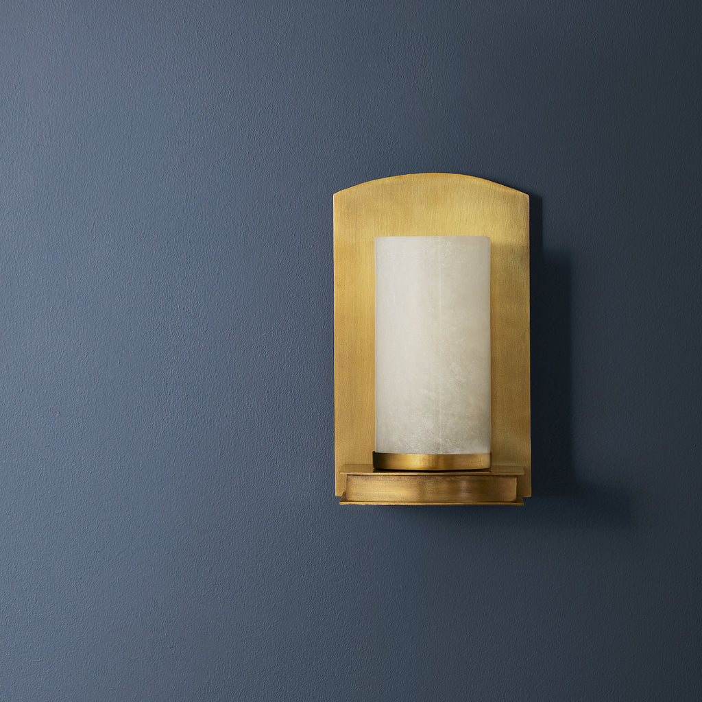 Roly wall sconce in antiqued brass with an alabaster tube